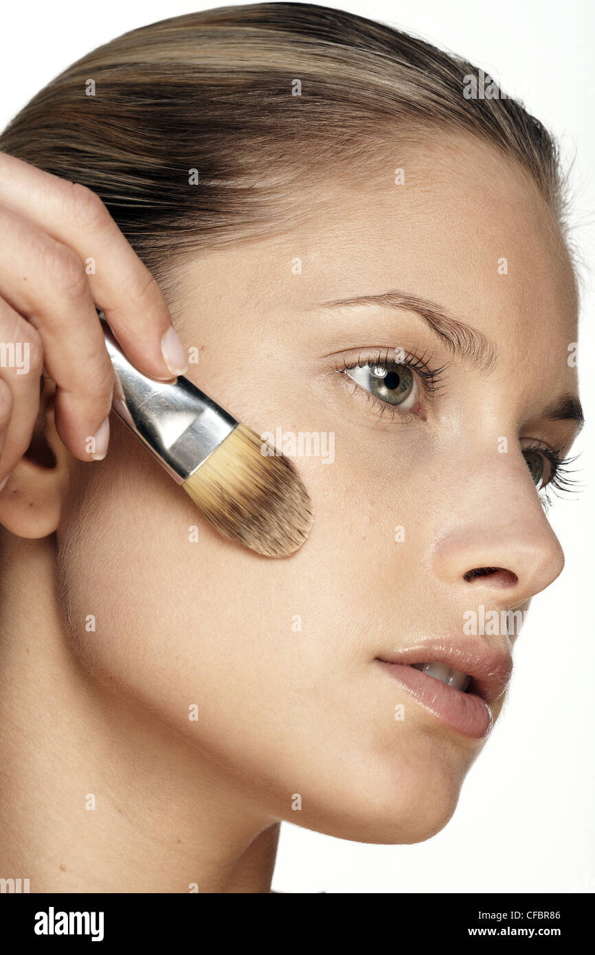 Female applying foundation with brush Stock Photo - Alamy