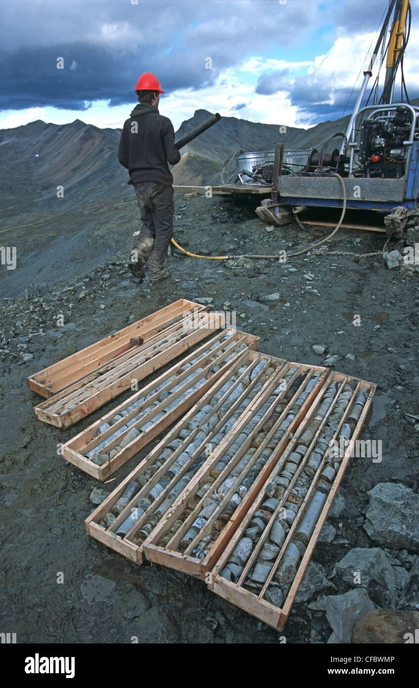 Drill rig operator taking drill pipe back to rig, Yukon Territory ...