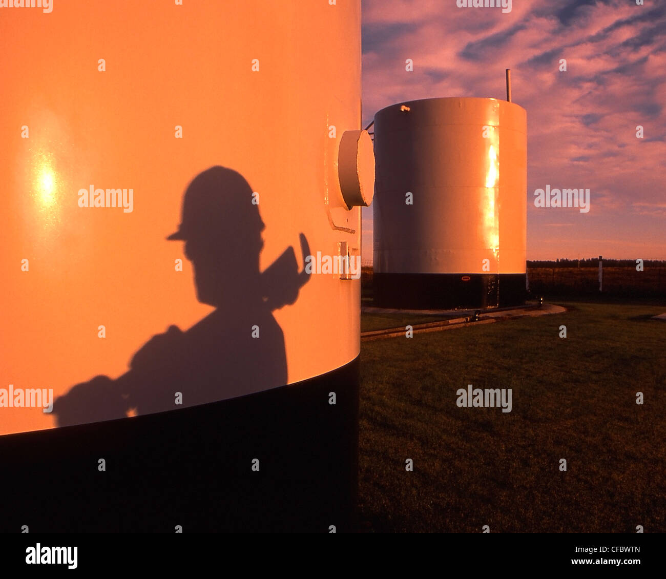 Oil industry worker's shadow on holding tank Stock Photo - Alamy