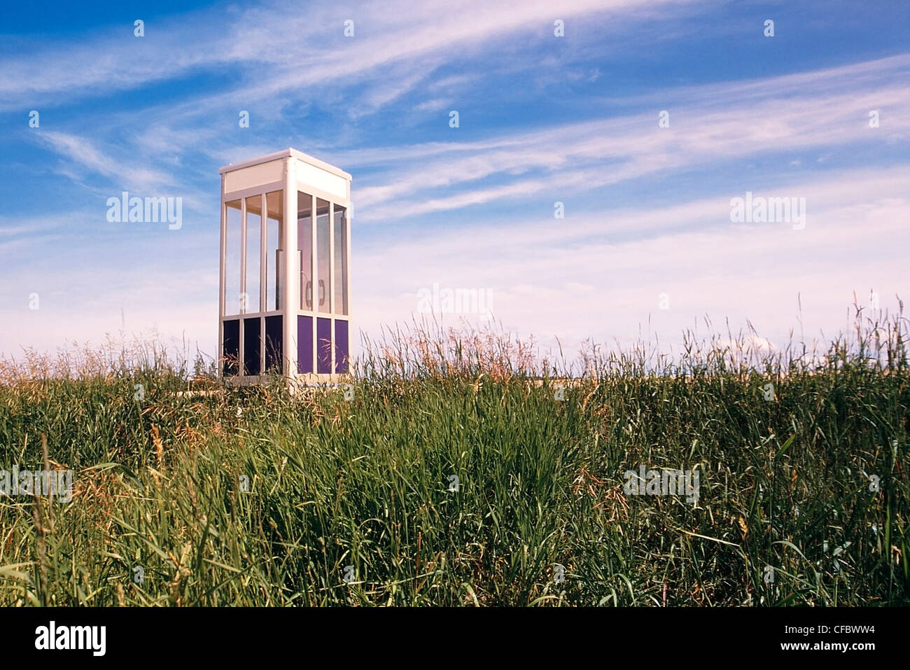 Phone booth on side of highway with tall grass Stock Photo - Alamy