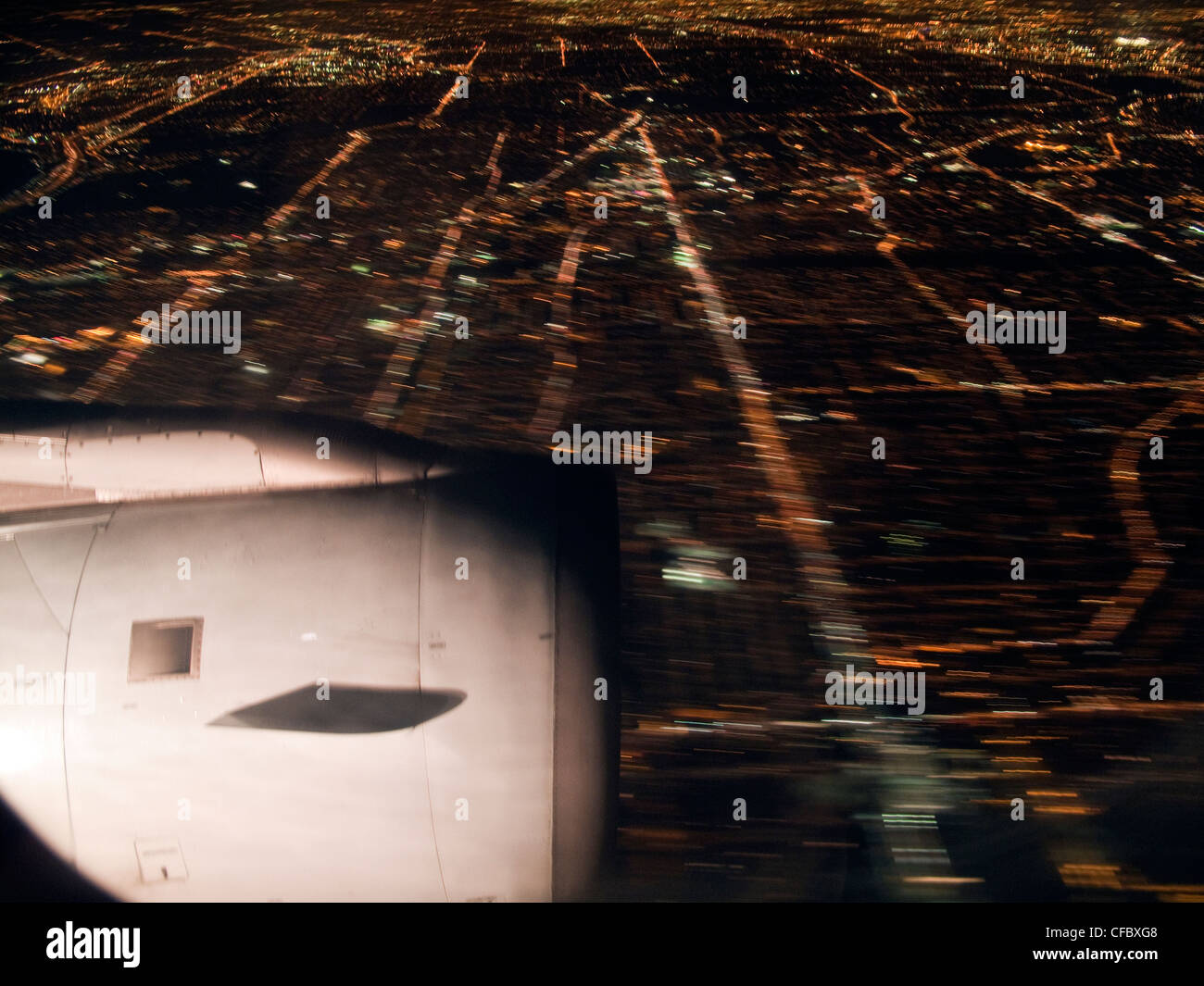 airplane engine at night during flight over the illuminated streets ...