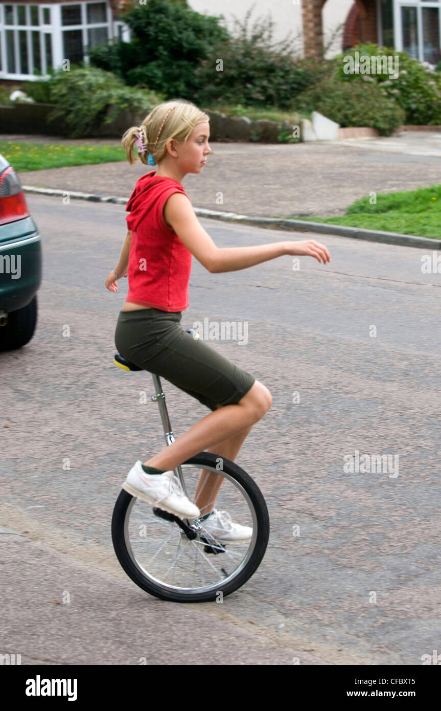 A young female riding a unicycle down the pavement Stock Photo - Alamy