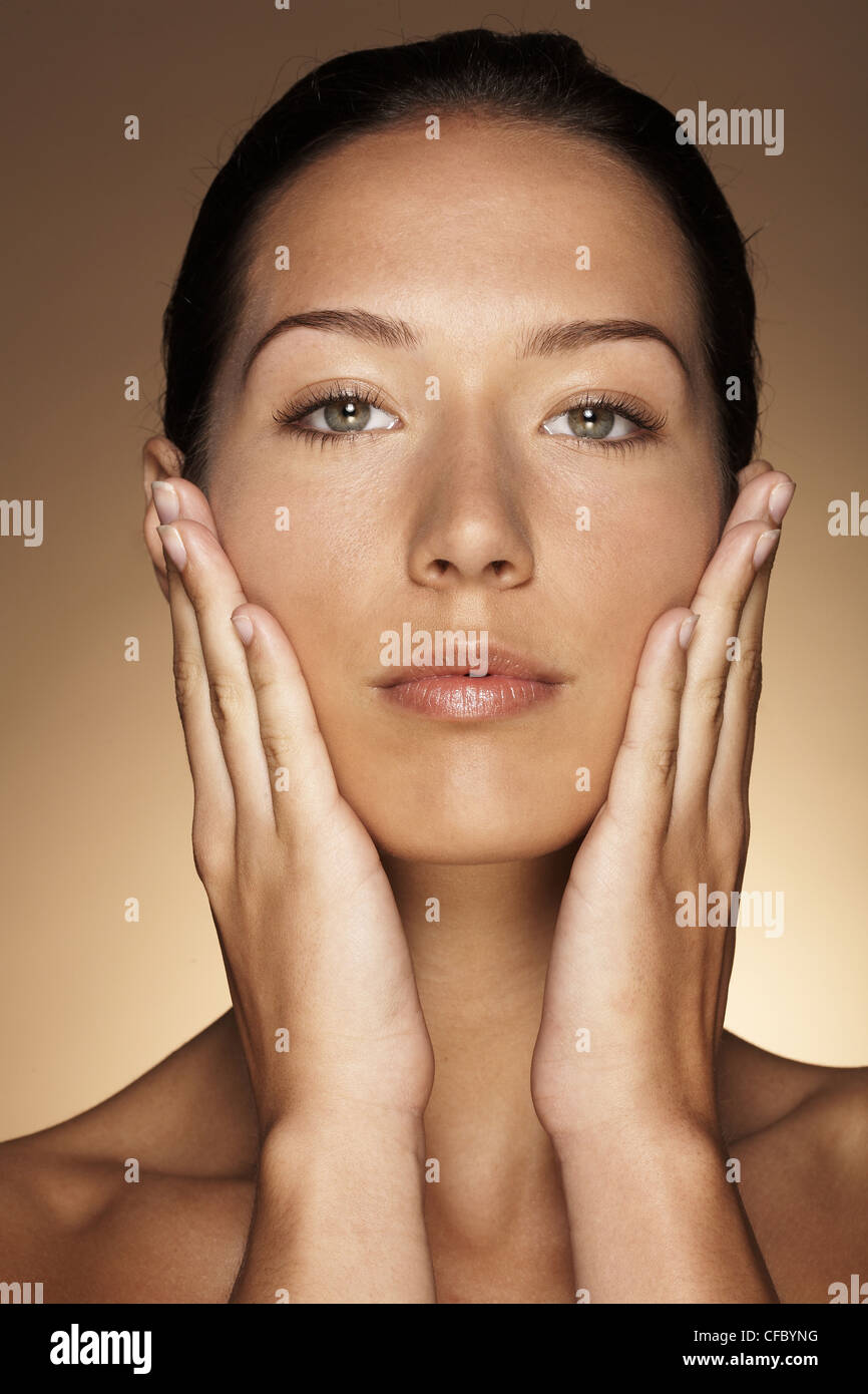 Female with her hands on her cheeks pulling her face up Stock Photo - Alamy