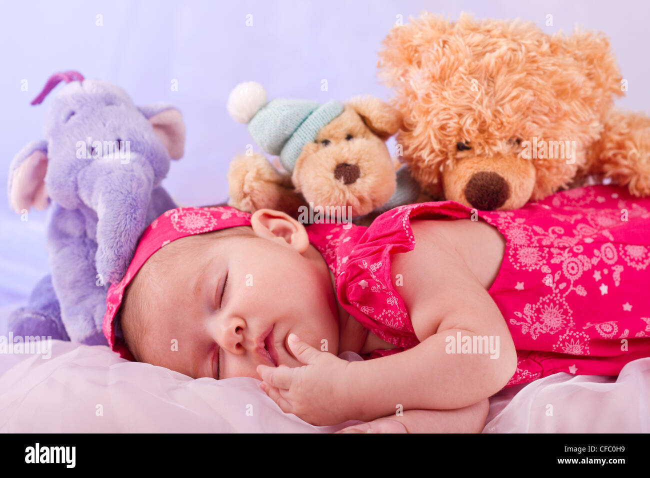 View of a newborn baby on smooth bed with stuffed toy sleeping Stock ...