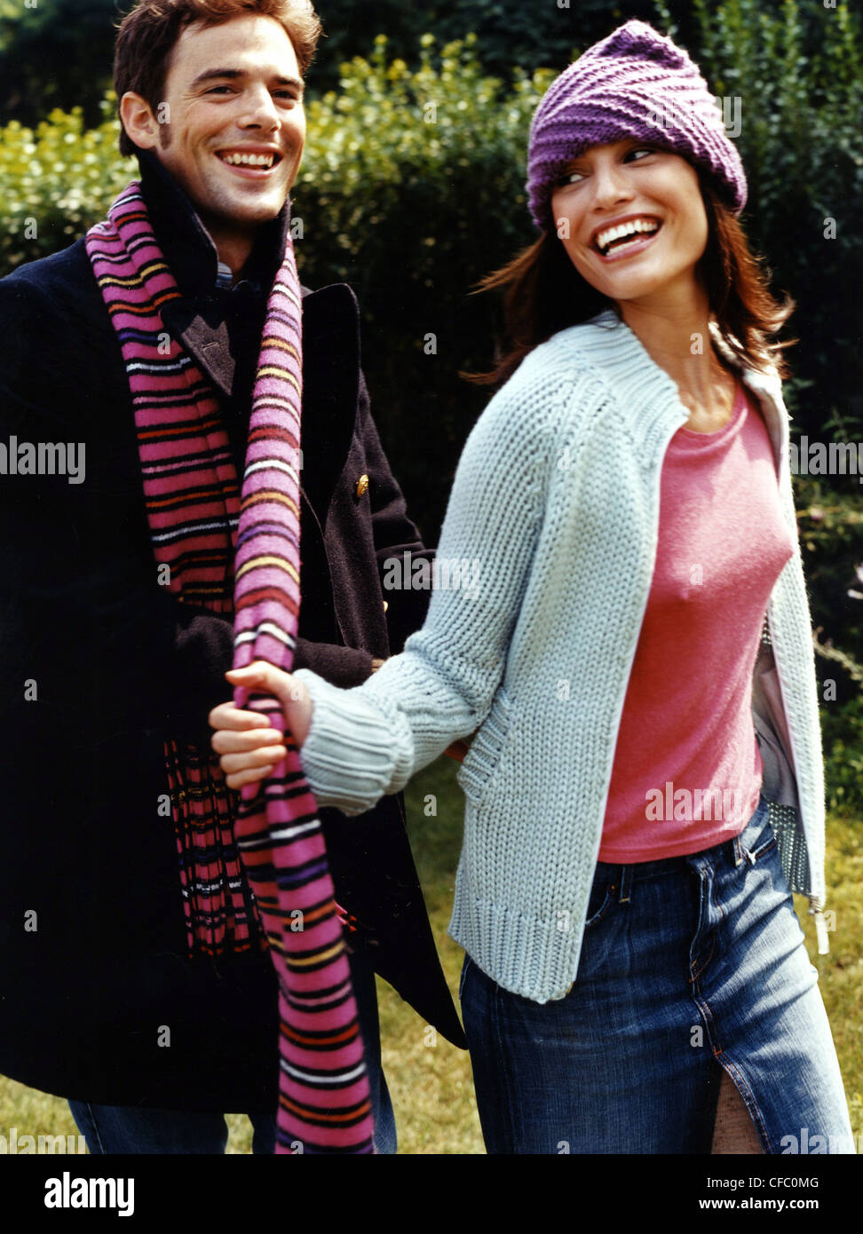 Couple walking outdoors, female grabbing hold of males scarf Stock ...