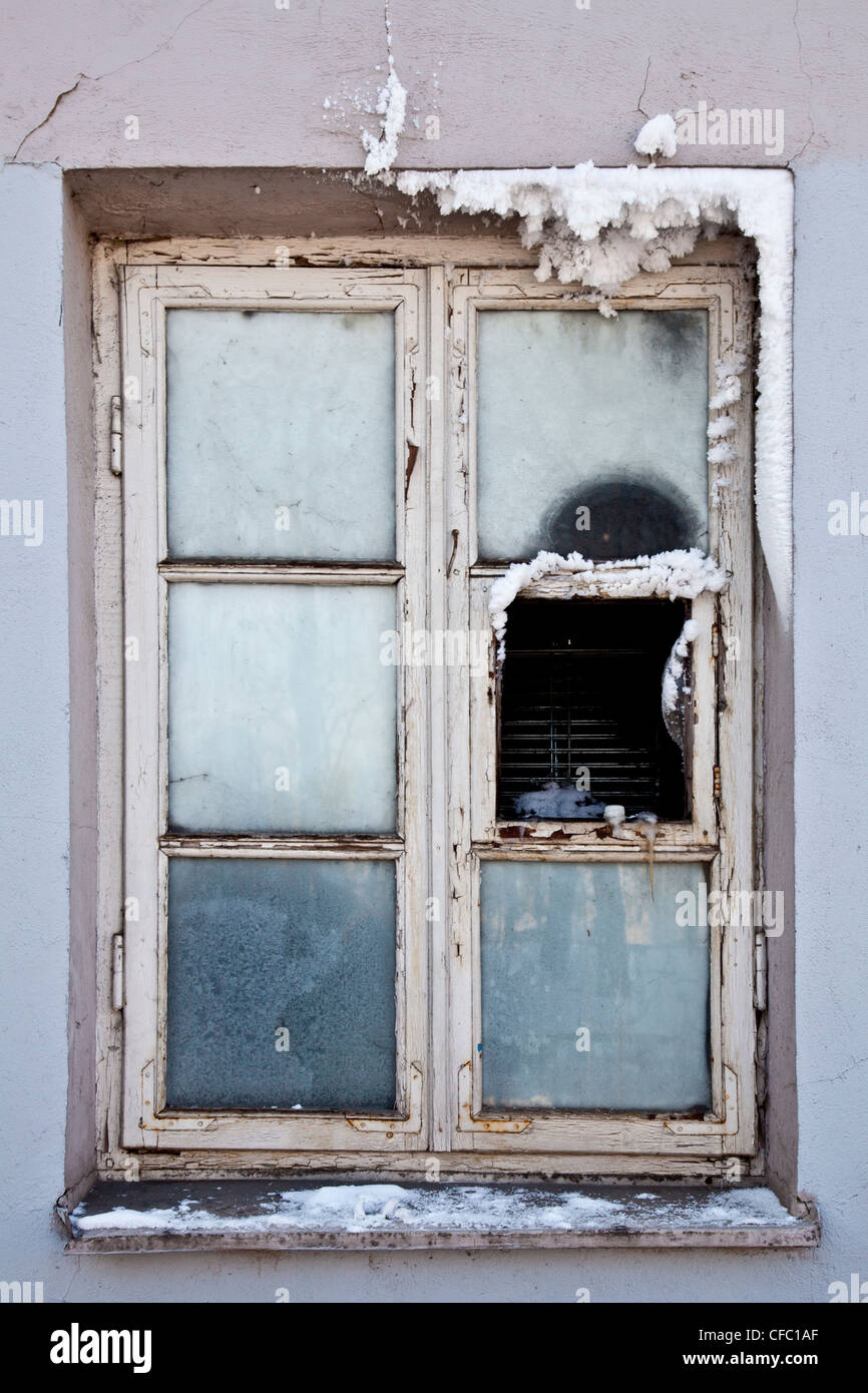 A broken window with ice and snow covering it in the extreme -25 degree ...