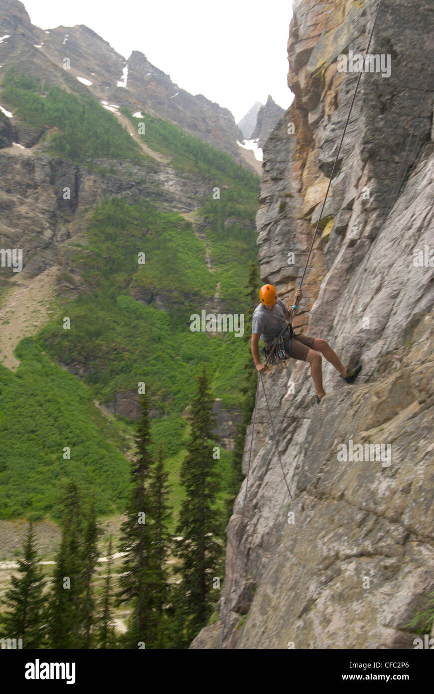 A climber rappeling down a cliff near Lake Louise, Alberta Stock Photo ...