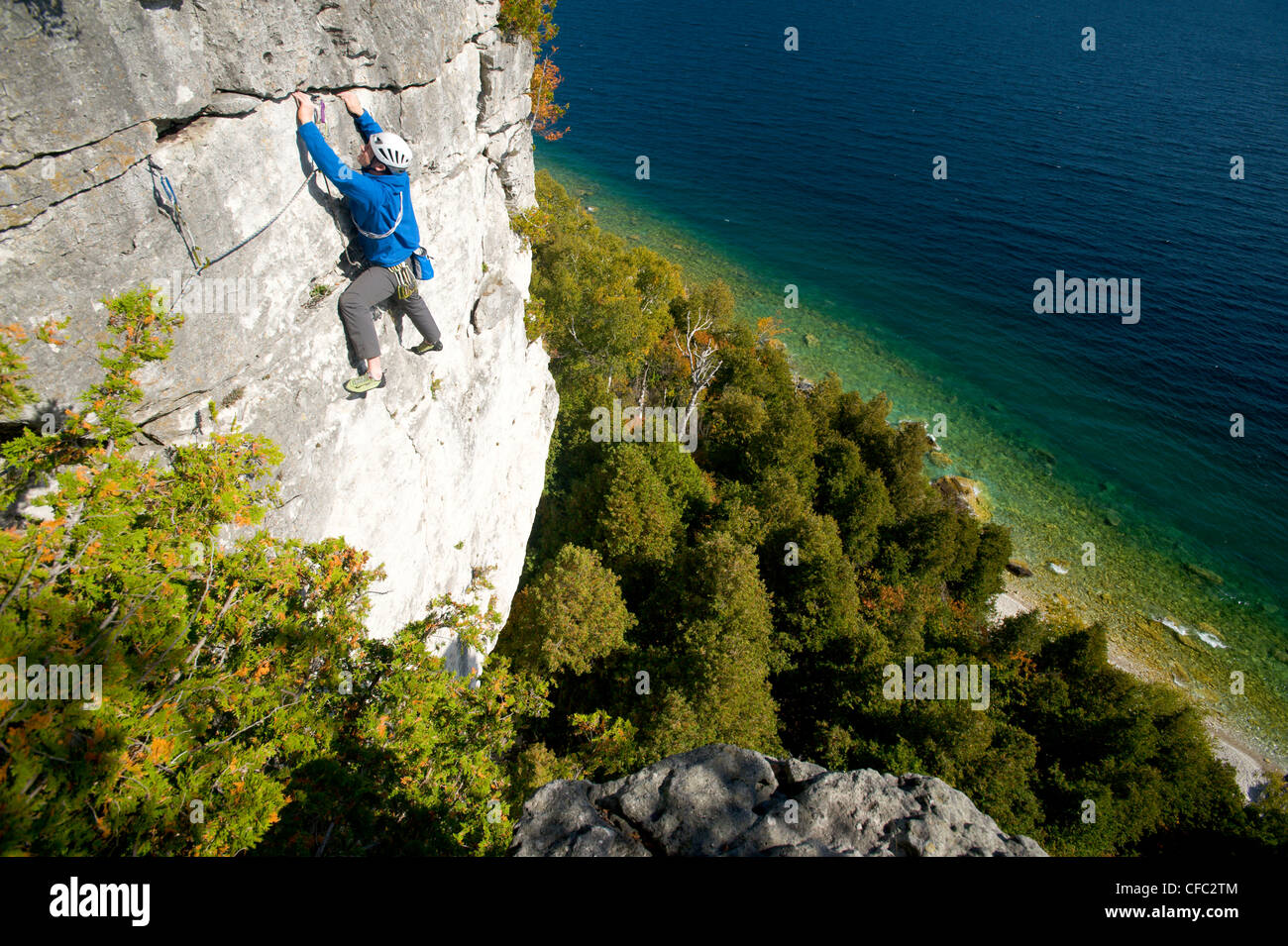 A rock climber on a high traverse at White Bluffs, Bruce Peninsula ...
