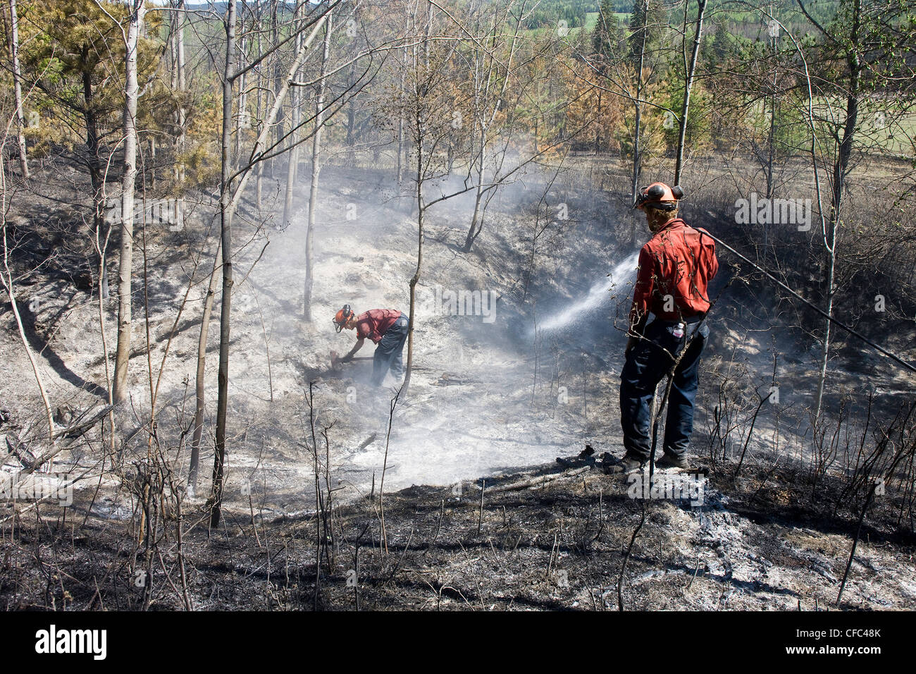 fire fighters putting out hot spots Stock Photo - Alamy