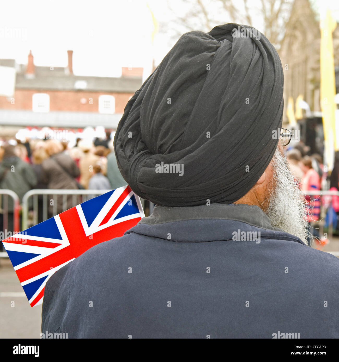 Rear view of a Sikh man waving a Union Jack at the Queen's visit to ...