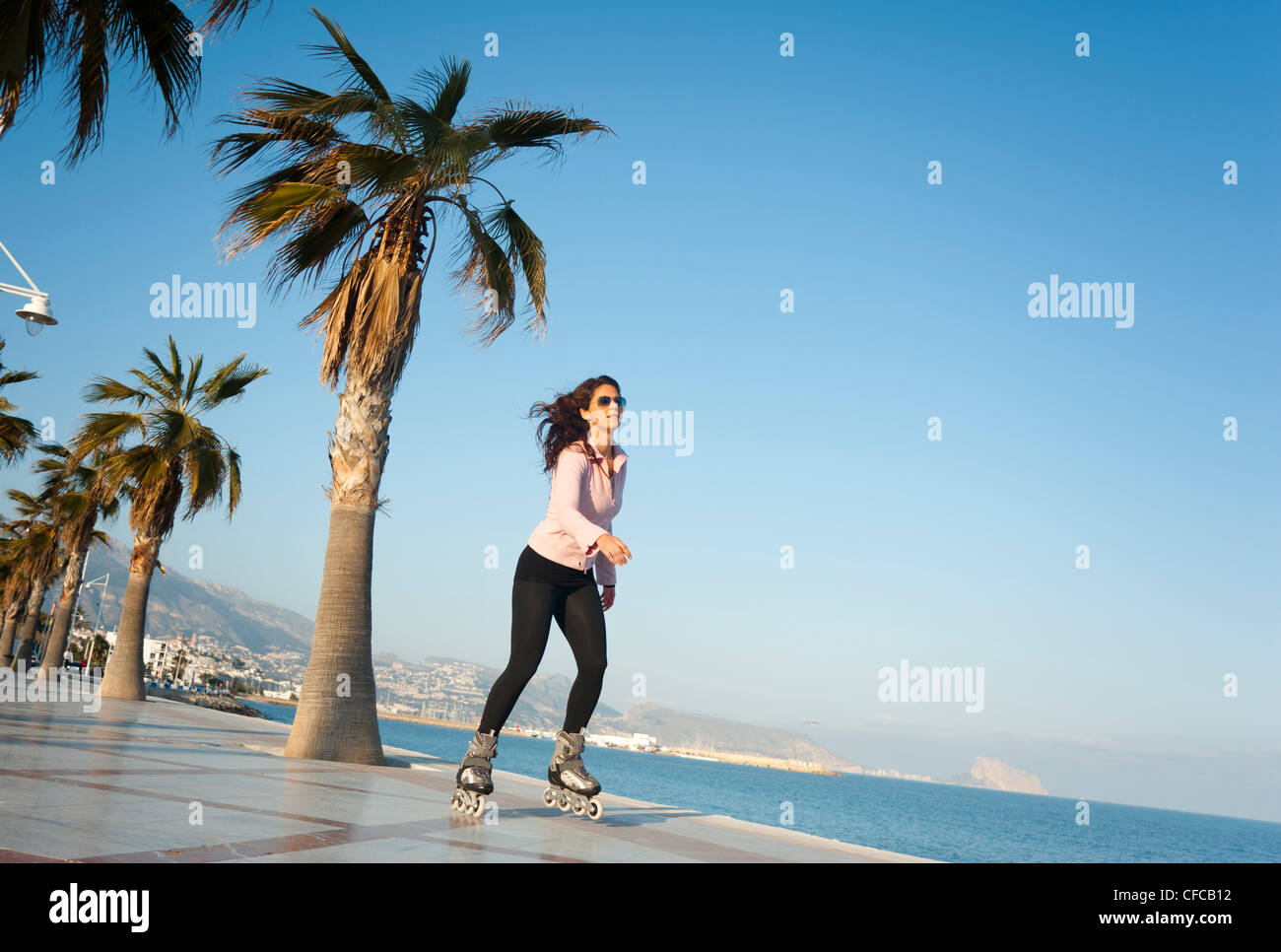 Woman skating along a sunny Mediterranean beach Stock Photo - Alamy