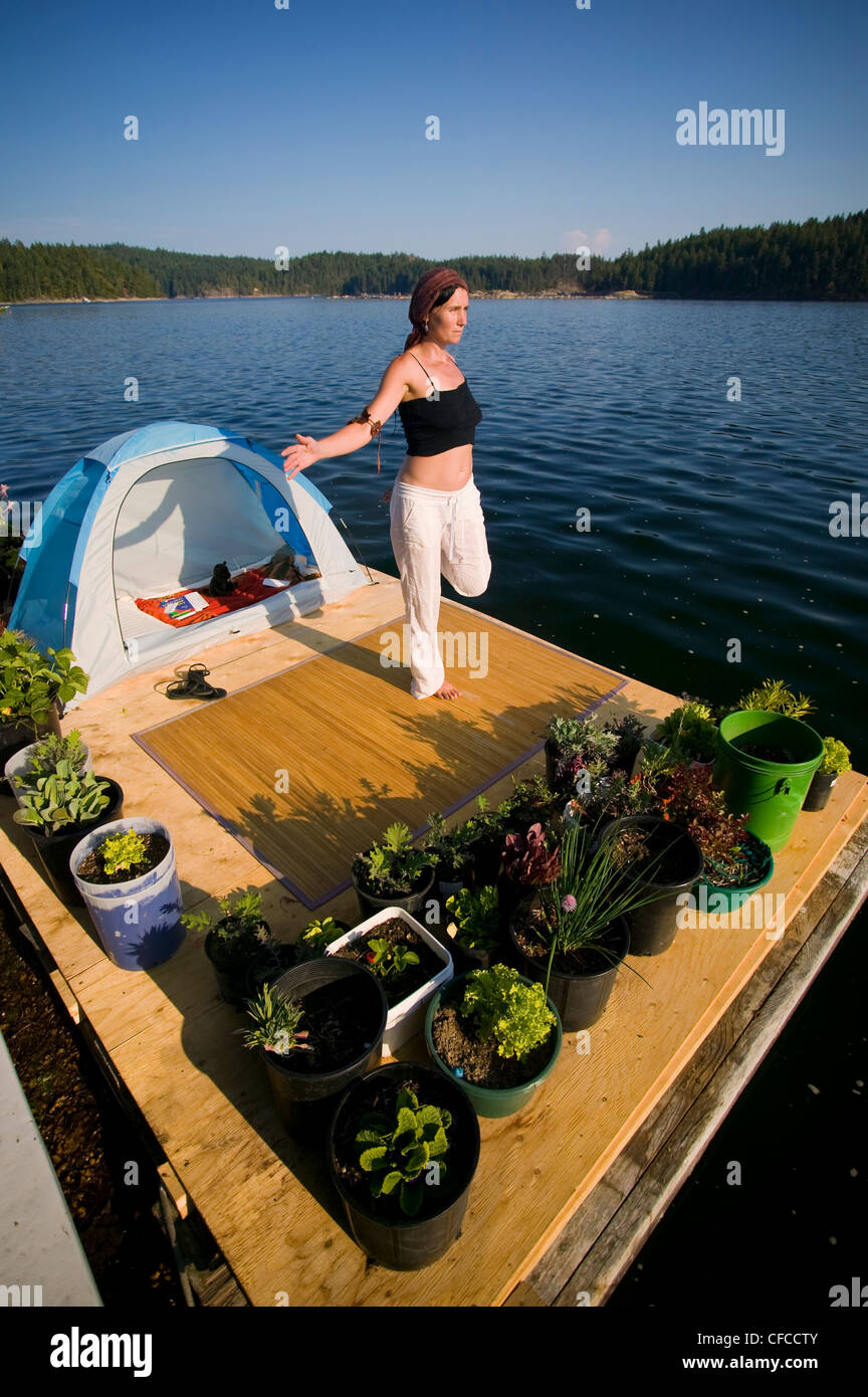 young woman who lives on her float house and greets each day with Yoga ...
