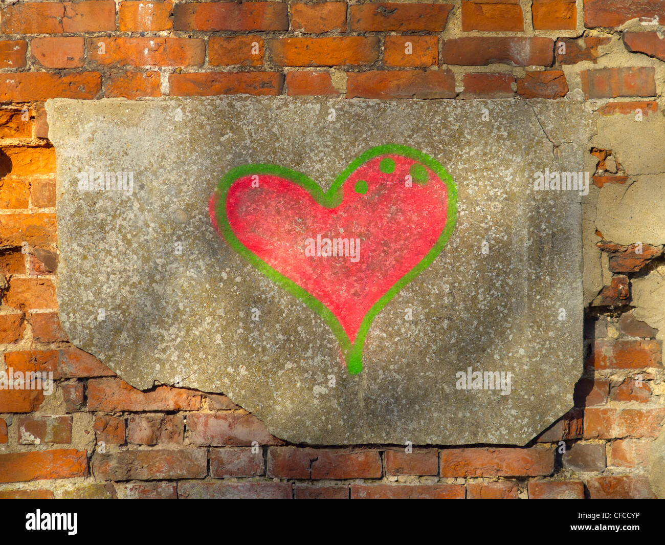A red heart-shape that has been spray-painted onto an old wall Stock ...