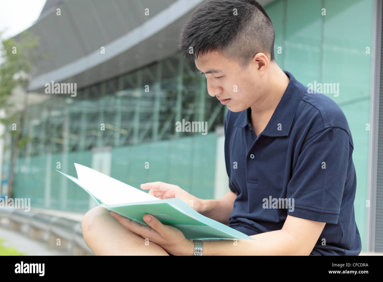 casual asian businessman texting on his book Stock Photo - Alamy