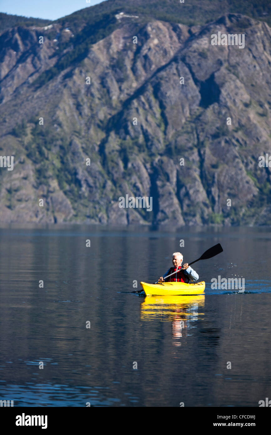 An adventurous retired man kayaking across a huge calm lake in Idaho ...