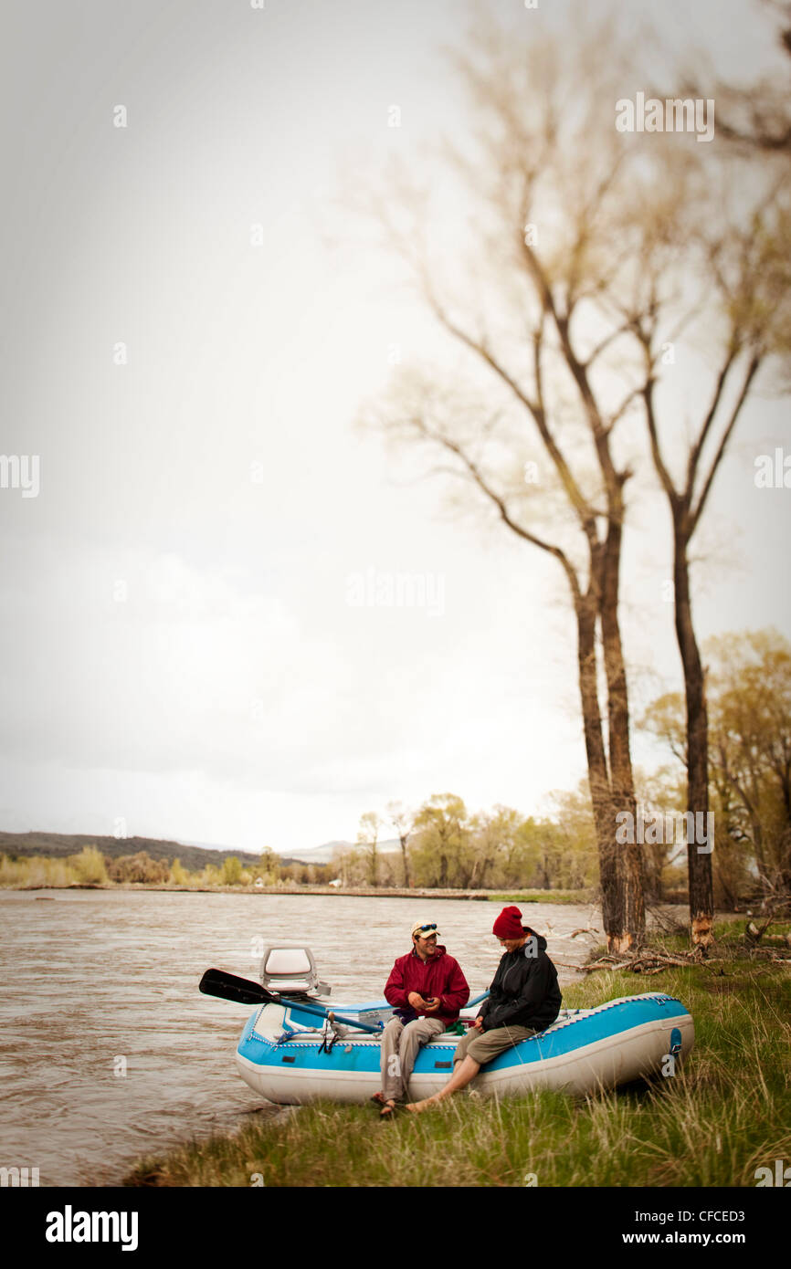 Two men smile while sitting on there raft in Montana Stock Photo - Alamy