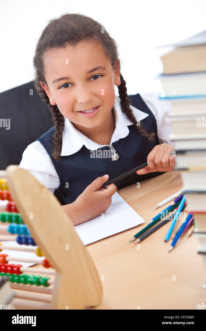 A beautiful young mixed race African American girl writing or drawing ...