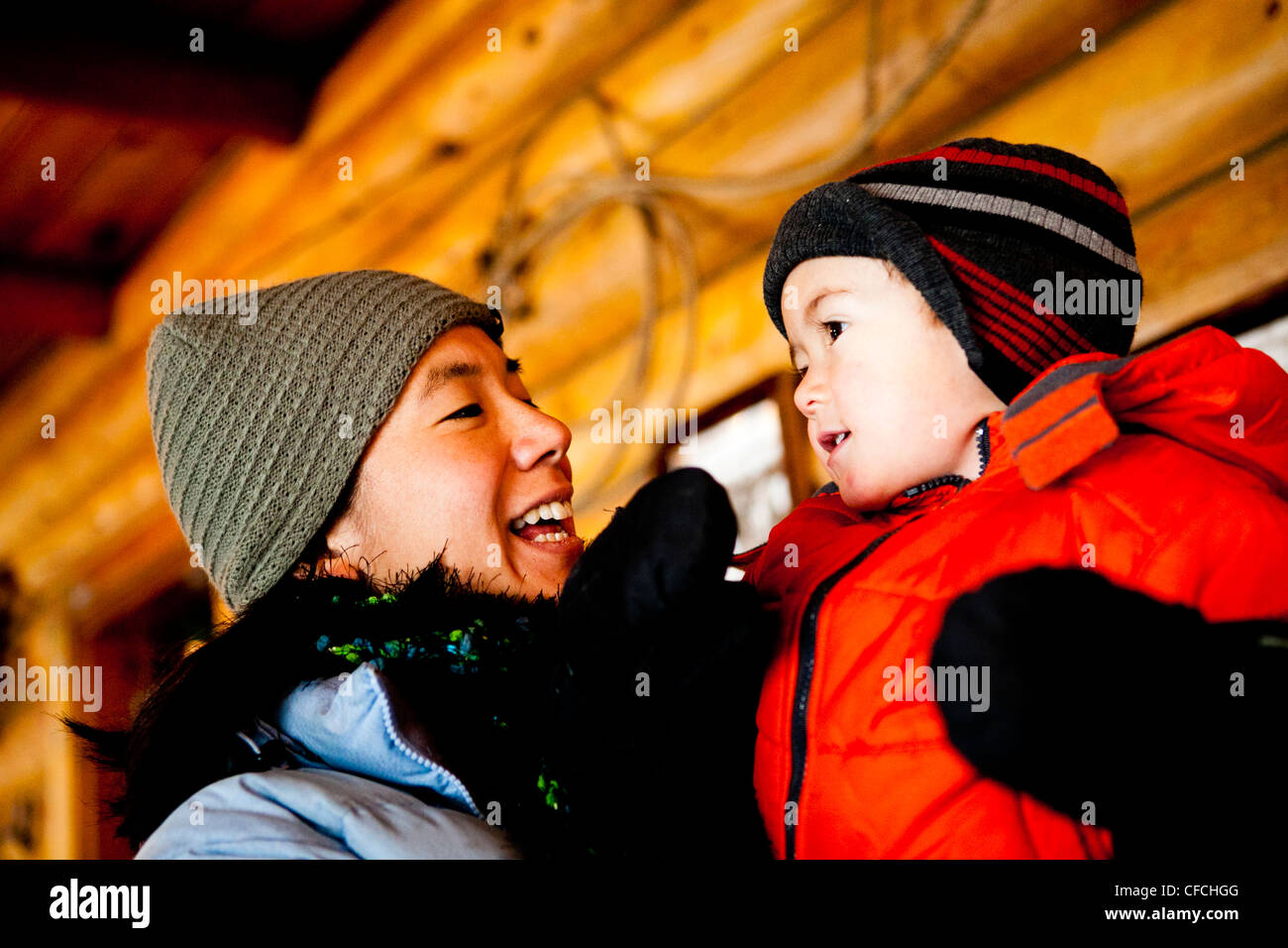 a woman is bundled up in warm clothes and stock cap / hat in a while ...