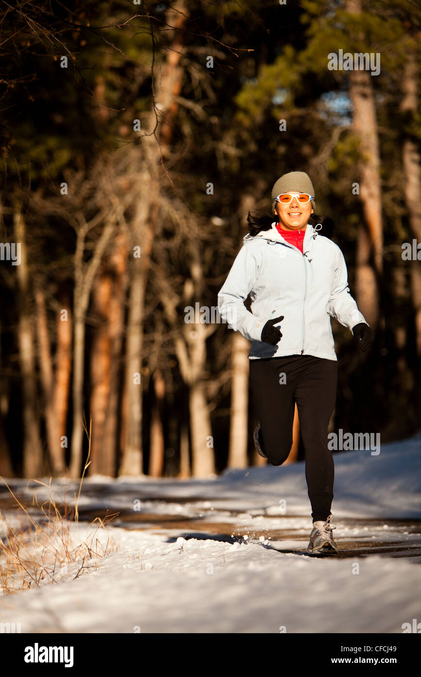 a Japanese-American woman runs through a glade of trees along a dirt ...
