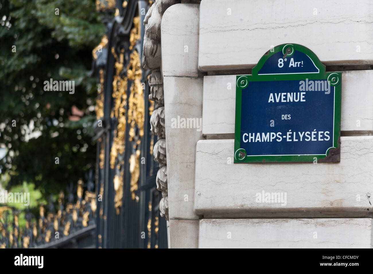 Champs Elysees street sign on a pillar and ornate gate in background ...