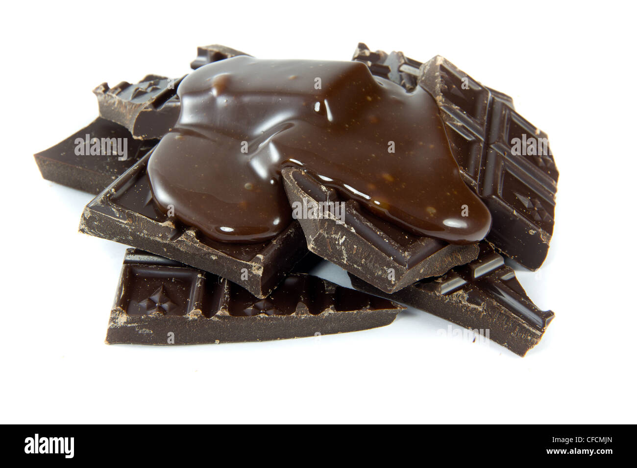 A picture of some broken chocolate pieces with some melted chocolate ...