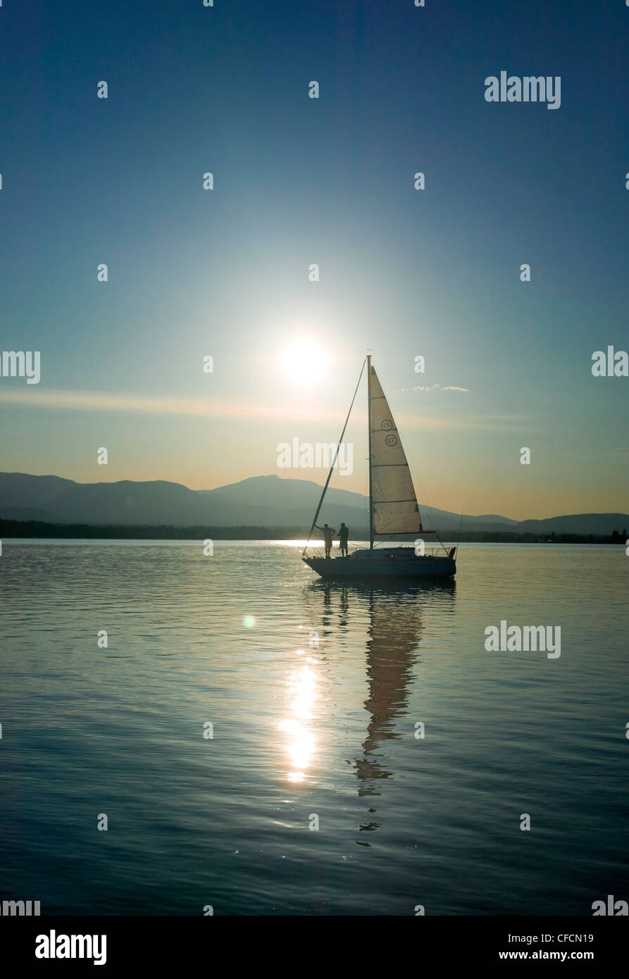 A Sailboat lies silhouetted against a setting sun in Comox Bay. The ...