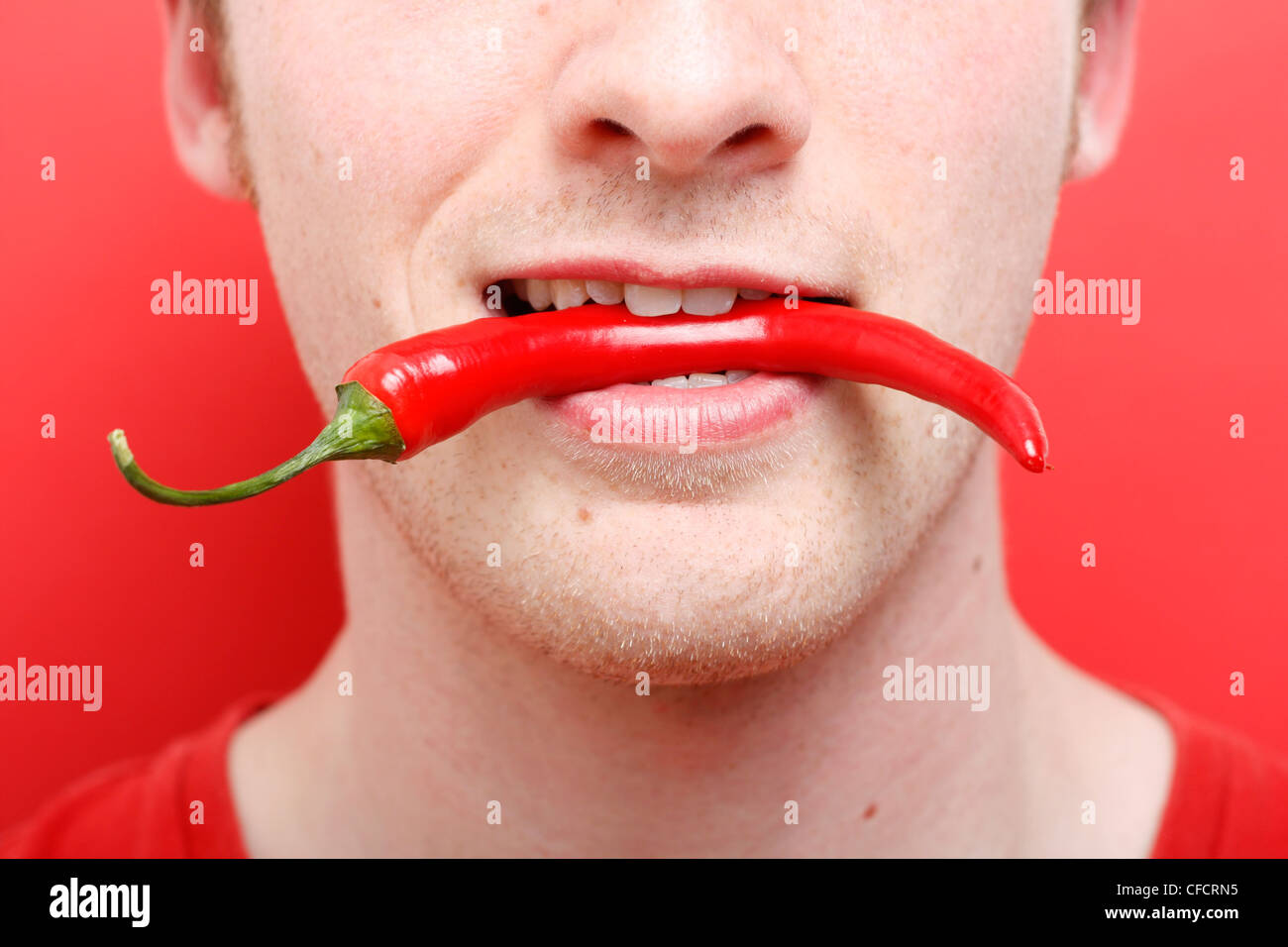 A man eating chili pepper Stock Photo - Alamy