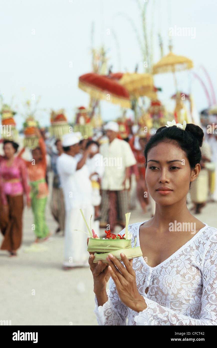 Young woman carrying offering at a ceremony in Bali, Indonesia ...