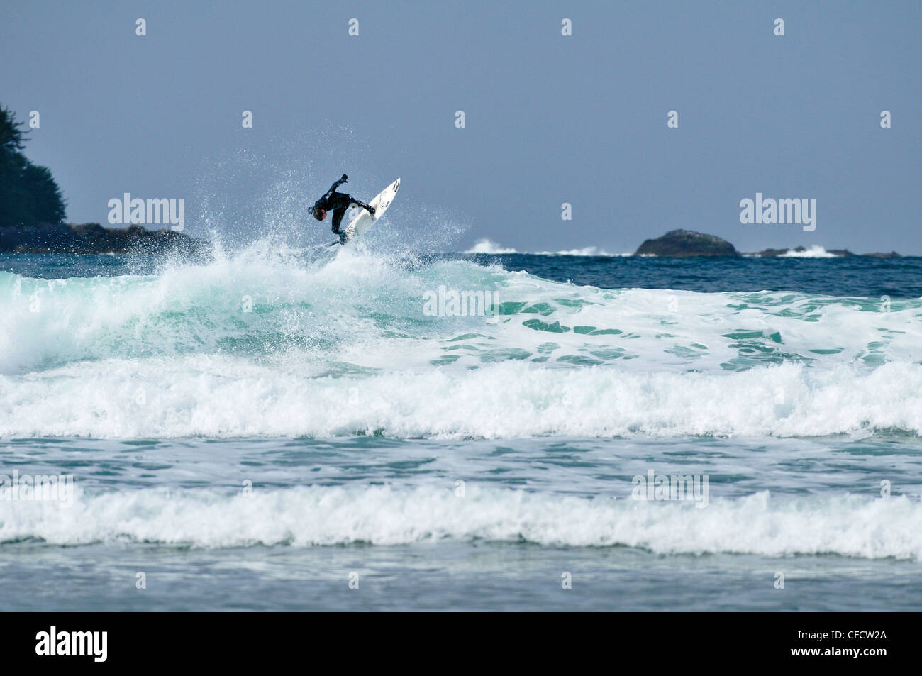 Surfer getting air on the crest of a wave at Chesterman Beach, Tofino ...