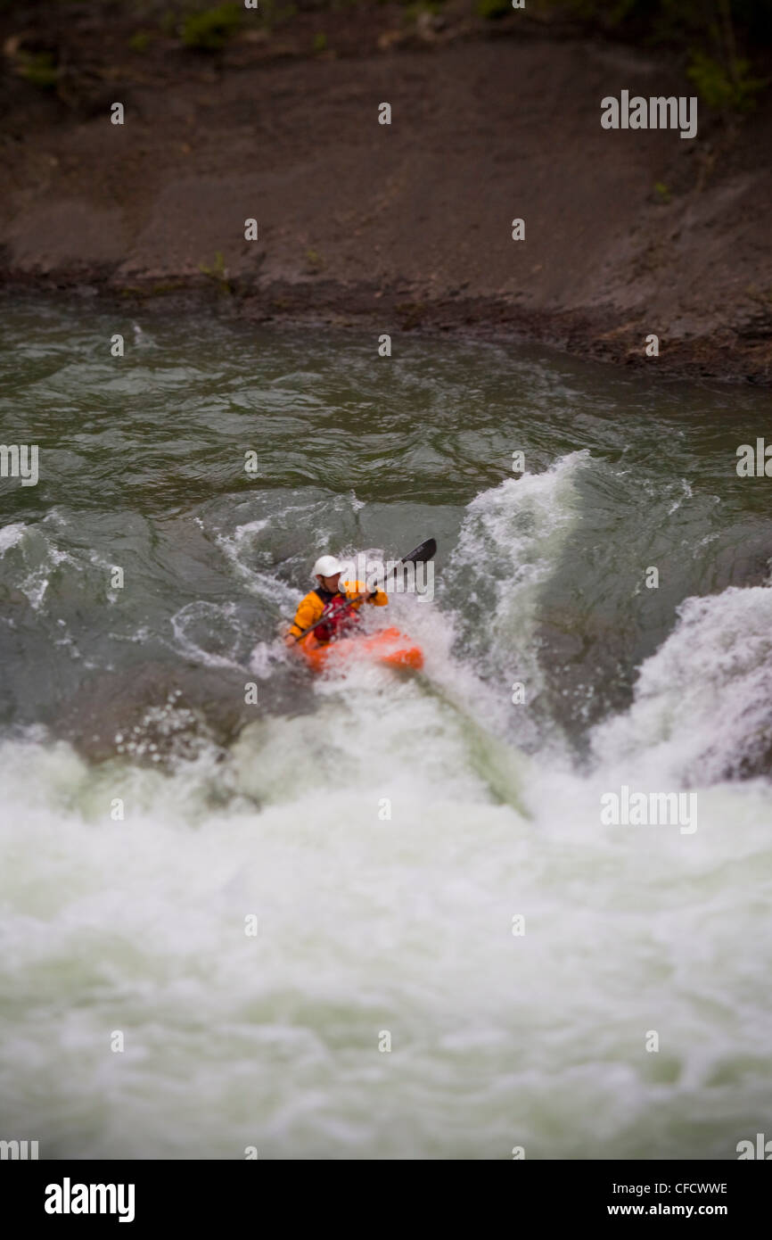 A male kayaker drops a ledge on the Highwood River, Alberta, Canada ...