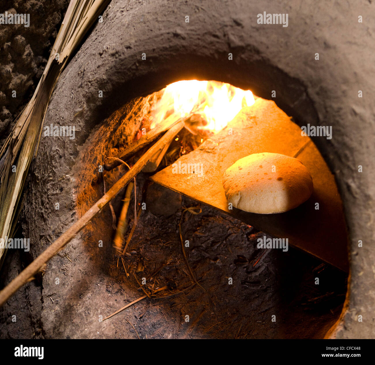 Freshly-baked bread in a traditional communal clay oven in the town of ...