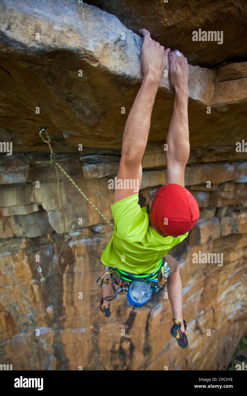 A young man rockclimbing through a tough roof at Lost Boys crag in ...
