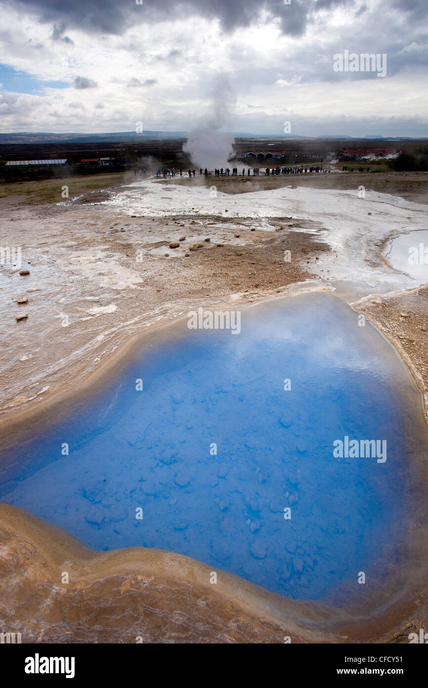 Blue water in geothermal pool with stream from Strokkur Geysir visible ...