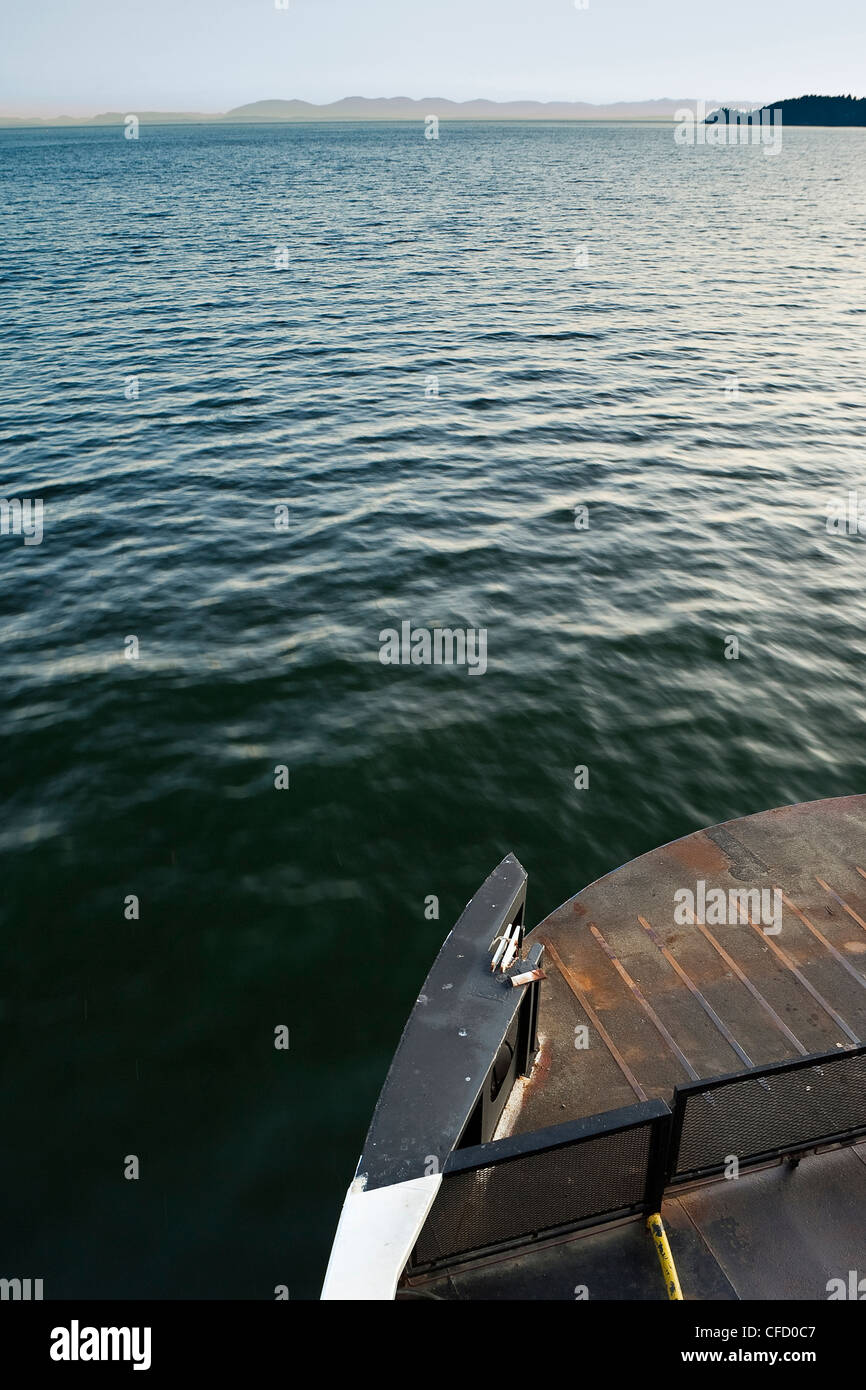 Bow of ferry boat crossing open water with islands on horizon, Strait ...