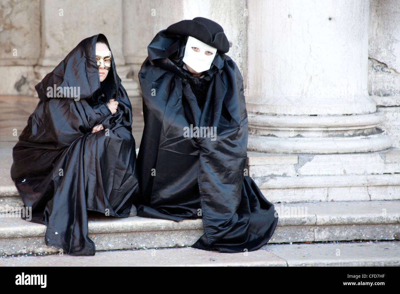 Couple sitting in black cloaks and masks carnival costume for the ...