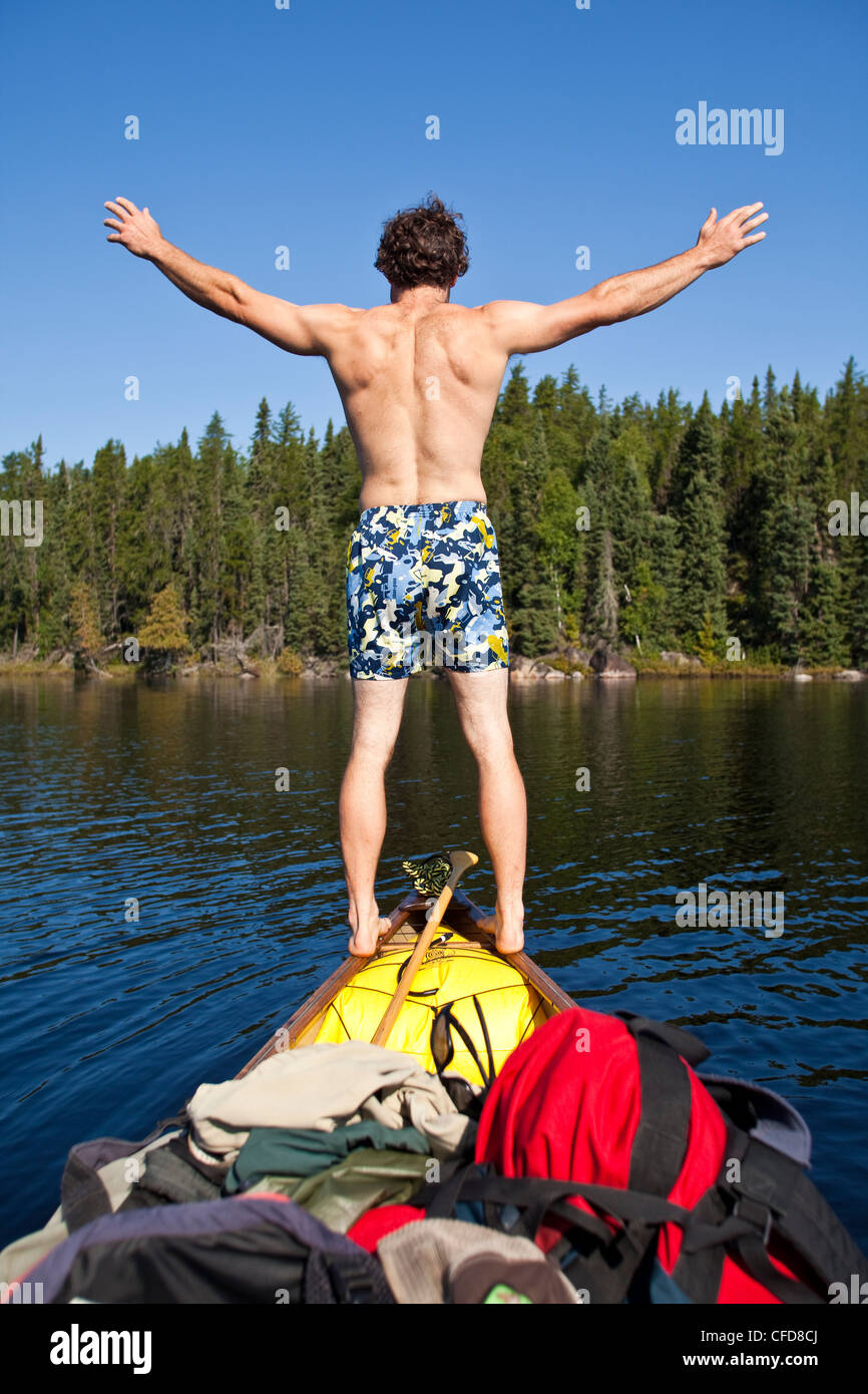 A man cooling off and diving into a lake on a hot day while canoeing ...