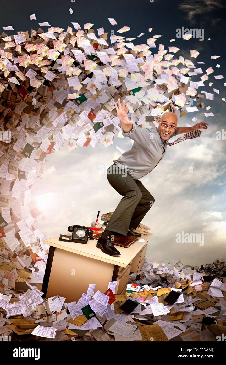 Businessman surfing in a sea of papers and files Stock Photo - Alamy