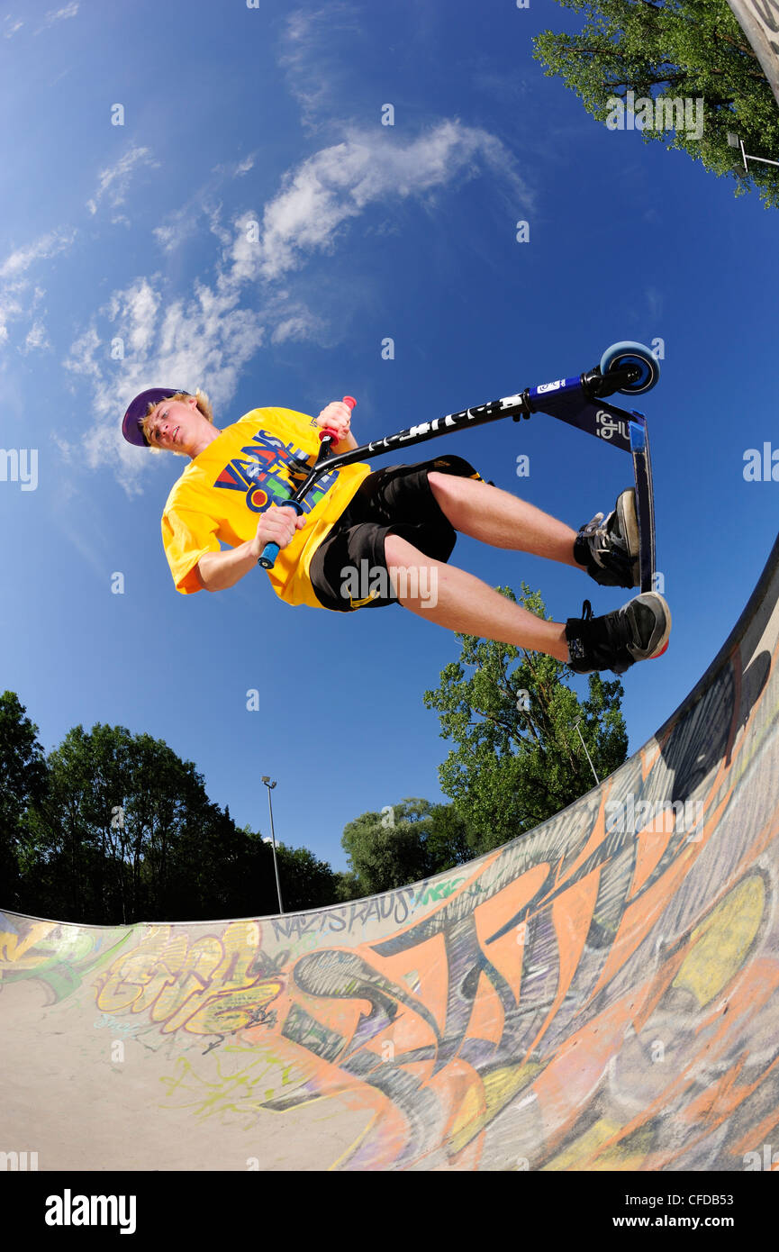 Young man performing jump with scooter, skatepark, Munich, Upper ...