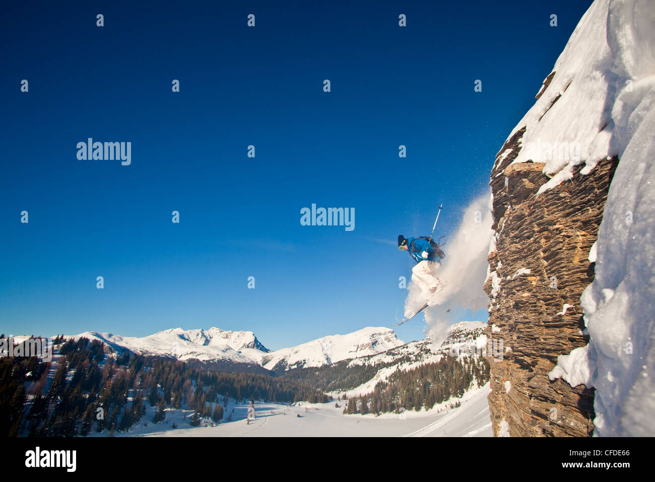 A young male skier catches off a cliff in Banff National Park, Alberta ...