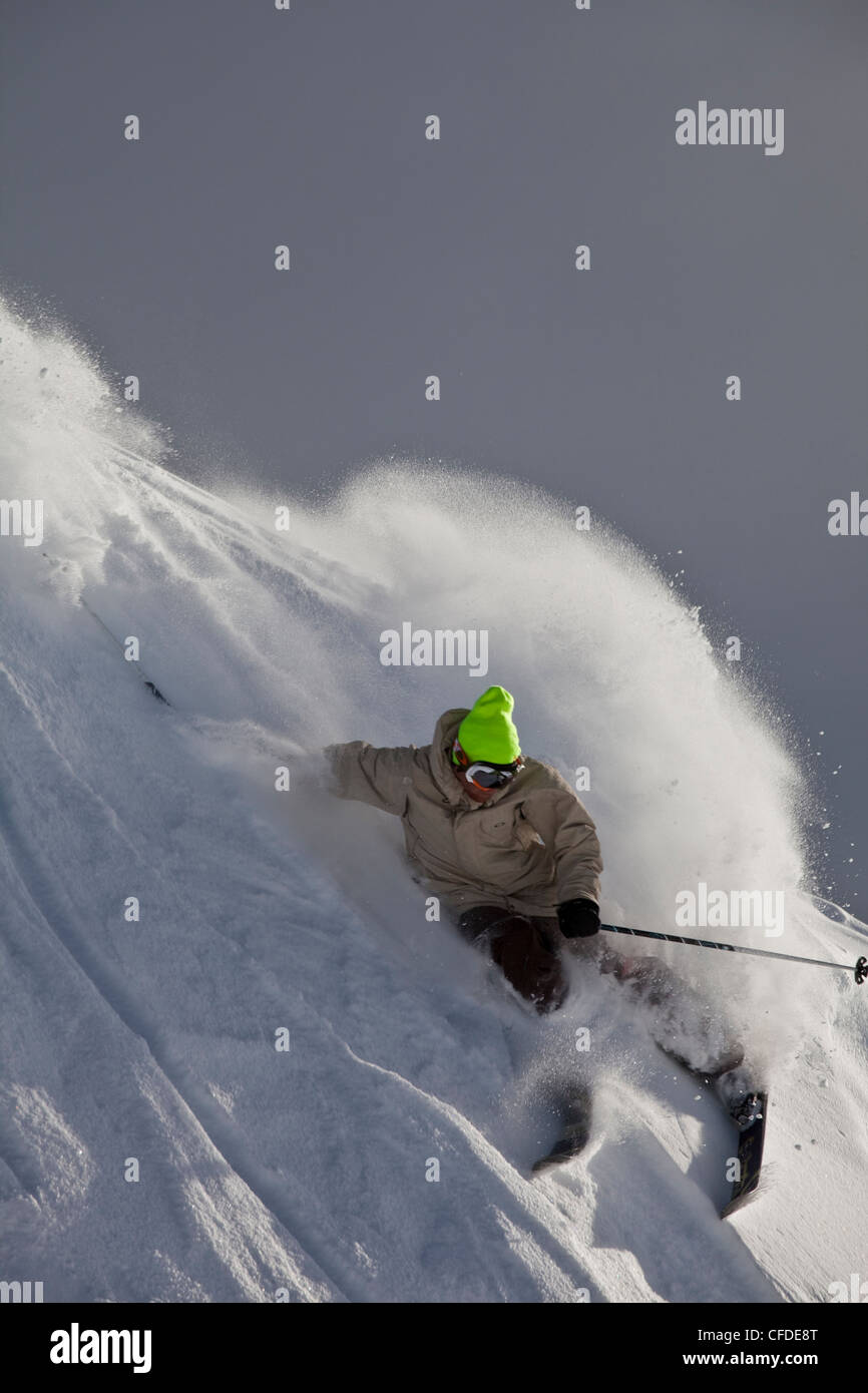 A young male skier slashes a powder turn, Kicking Horse Resort, Britsh ...