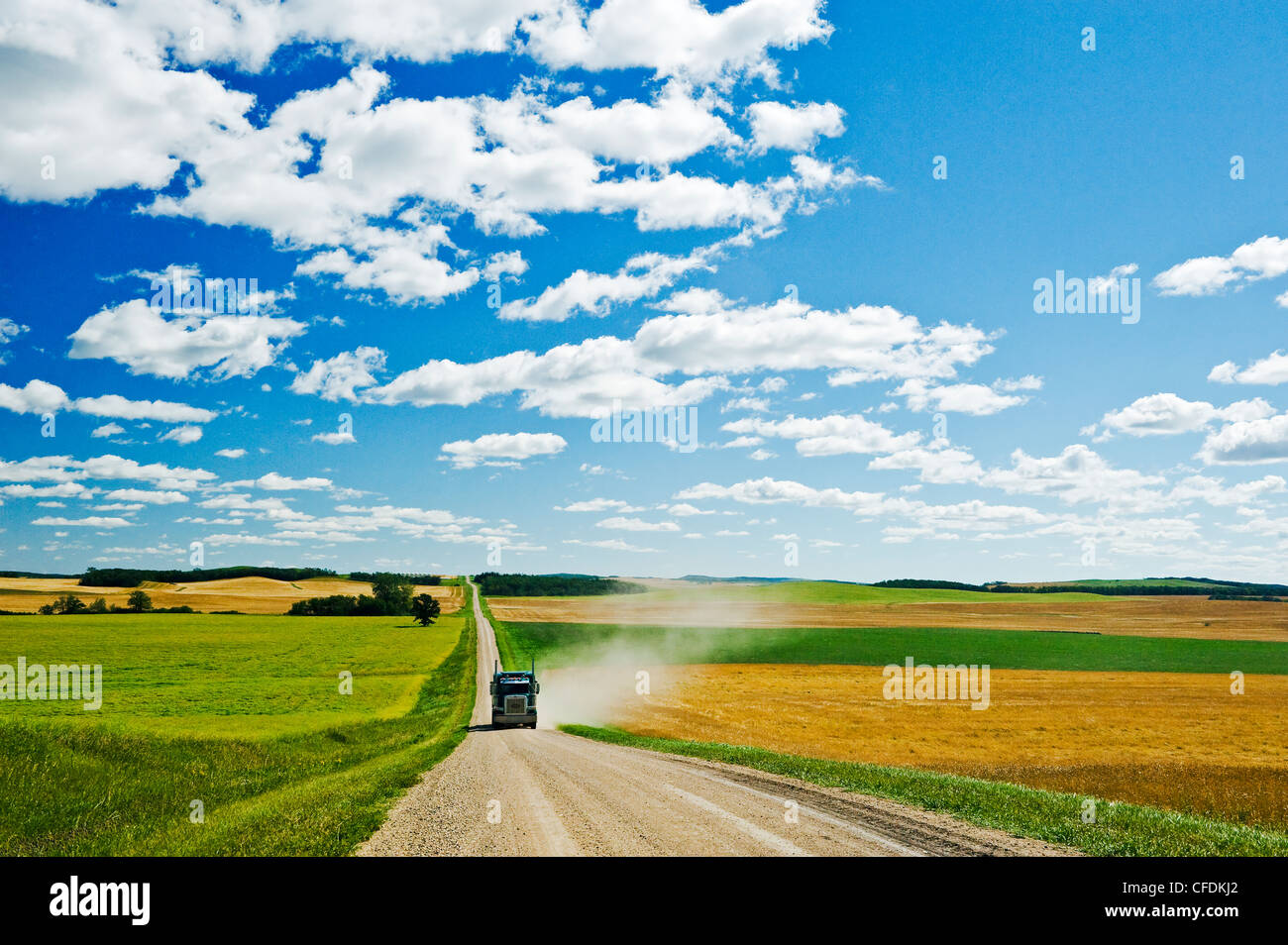 A truck on a country road with farmland on either side of the road ...