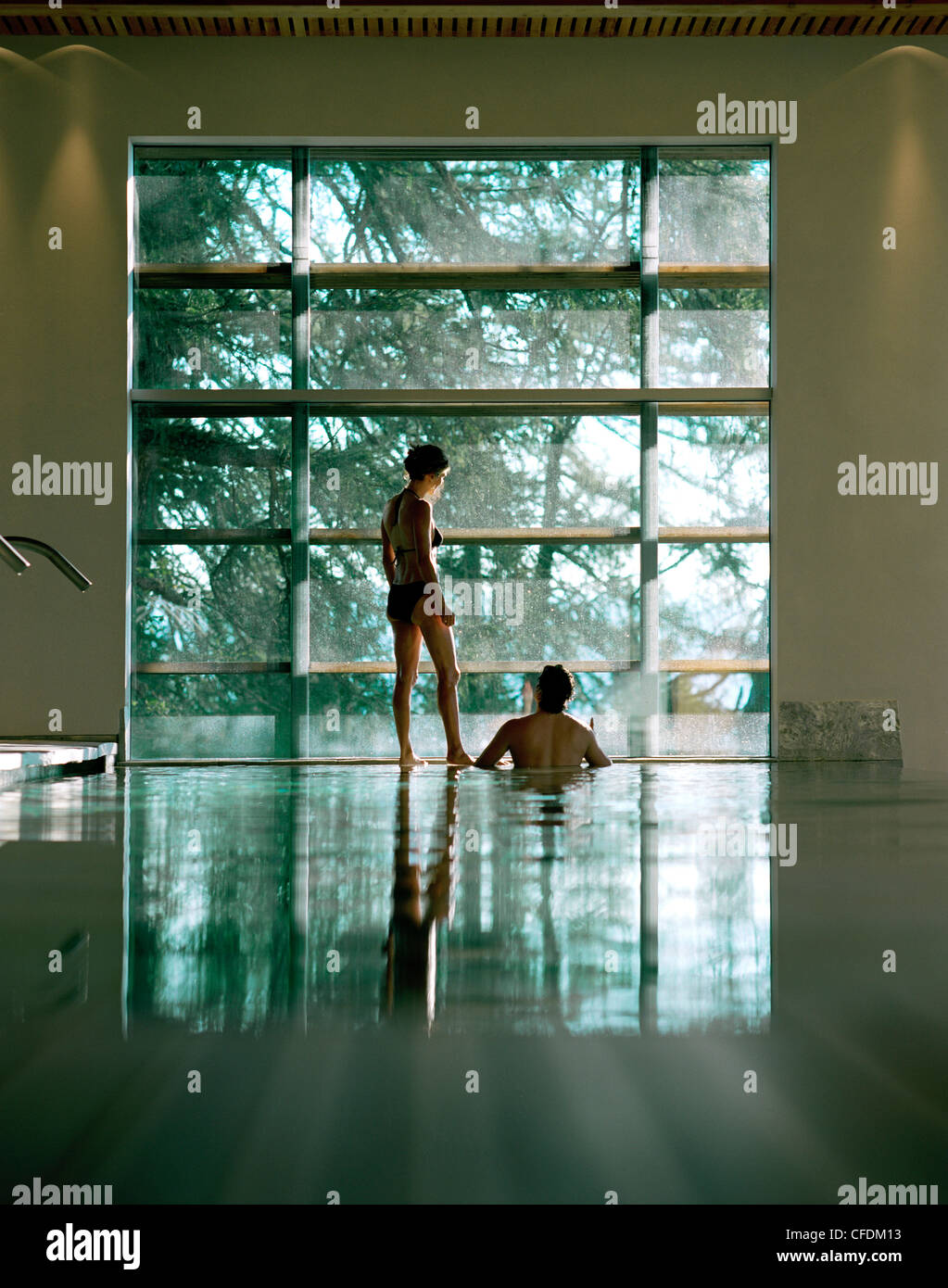 Couple at indoor pool looking out of a picture window, Vigilius ...