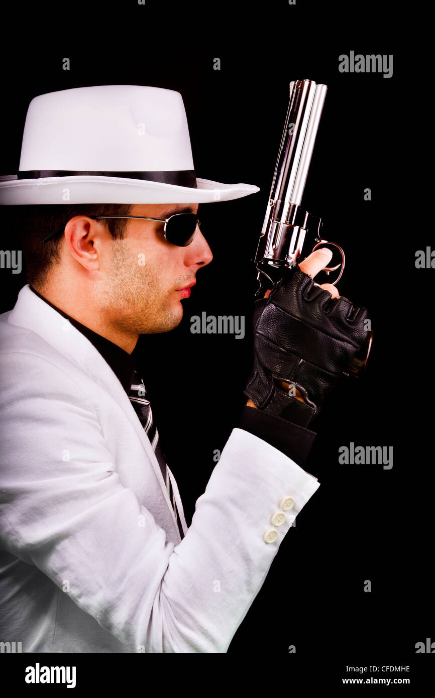 View of a white suit gangster man holding a gun Stock Photo - Alamy