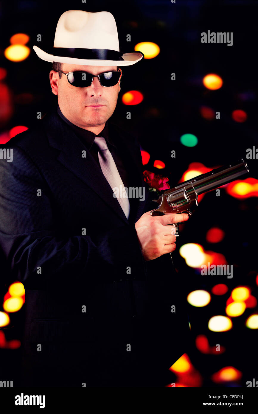 View of a dark suit gangster man holding a gun Stock Photo - Alamy