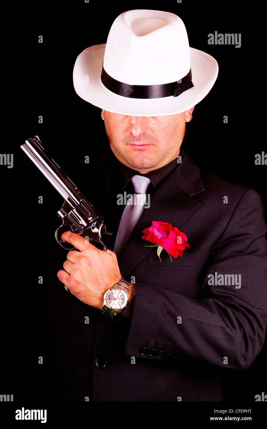 View of a dark suit gangster man holding a gun Stock Photo - Alamy