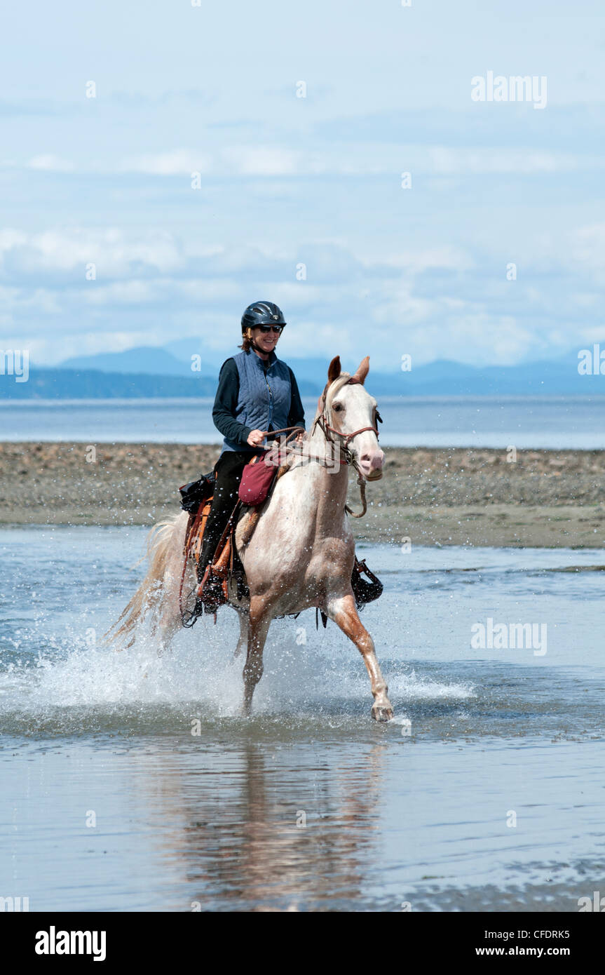 Women riding horses for recreation on the beach at Merville, Vancouver ...