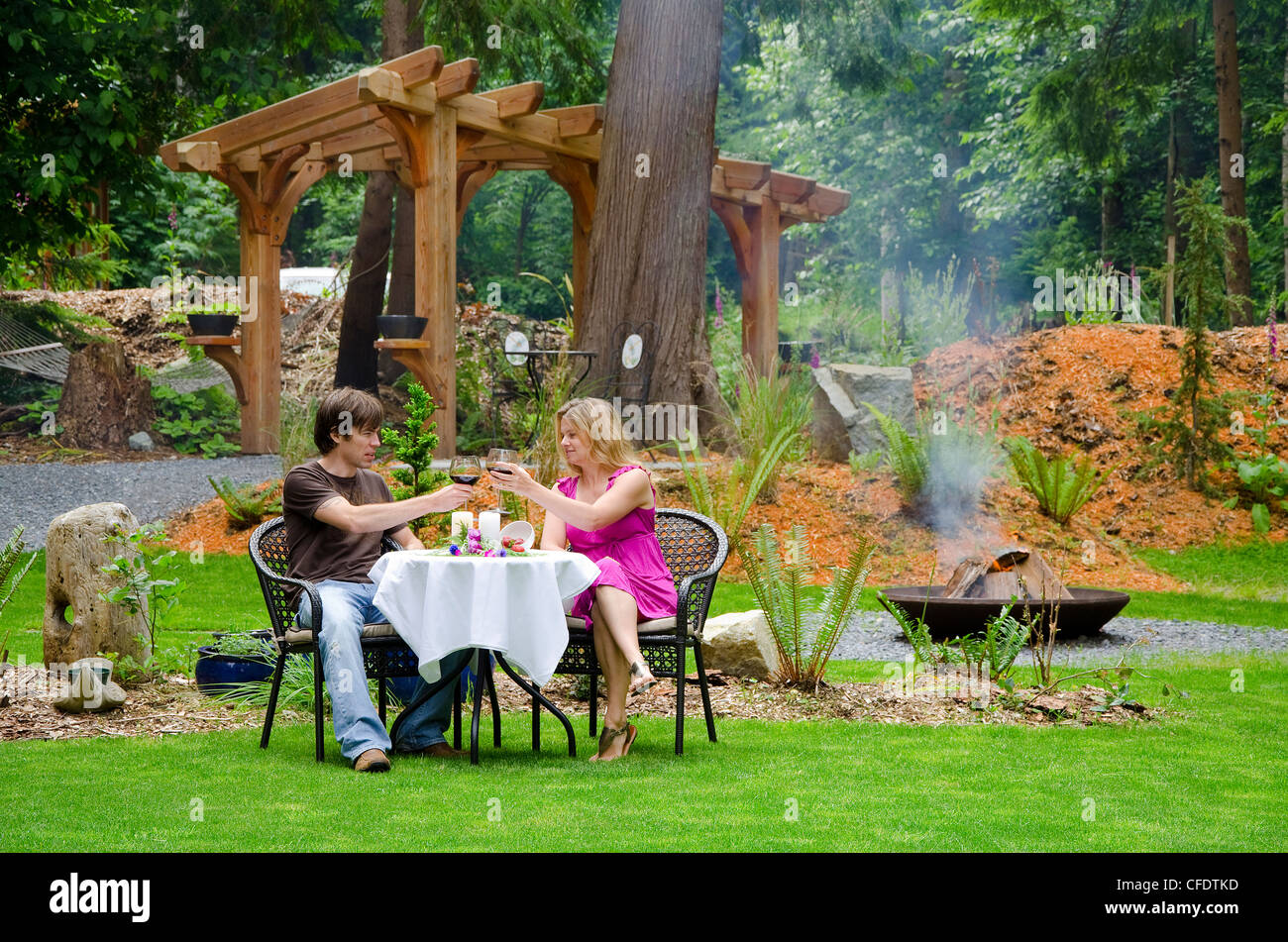 Young couple enjoy fireside dinner Savary Island Stock Photo - Alamy