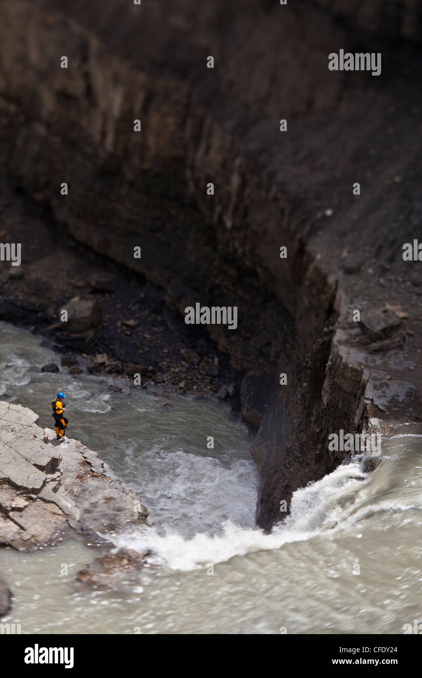 A male kayaker scouts a big waterfall on the Bighorn river, Nordegg ...