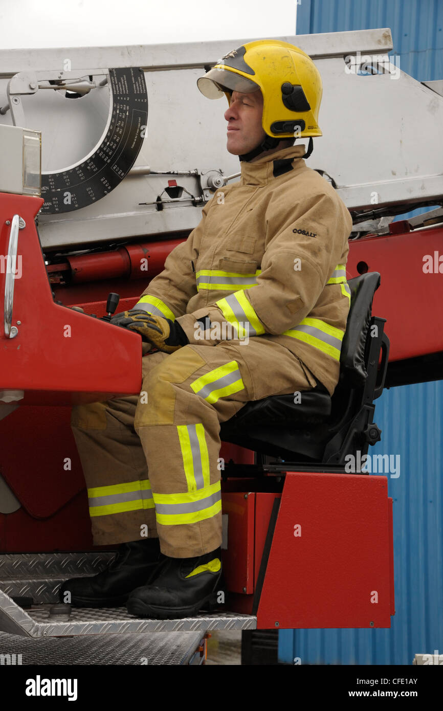 Fire service firefighter extendable rescue ladder operator controls his ...