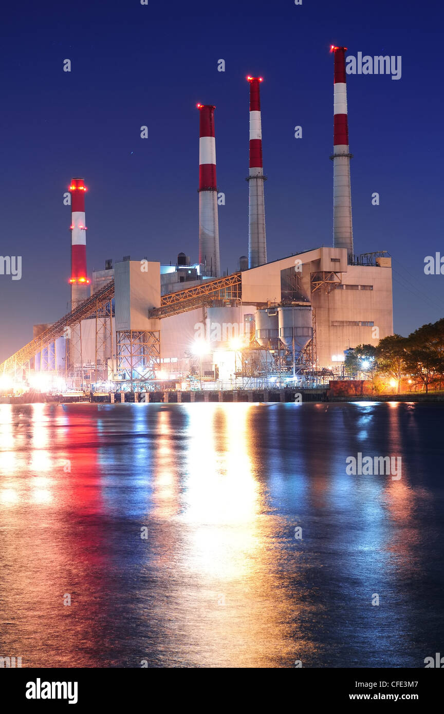 Factory over river at dusk Stock Photo - Alamy